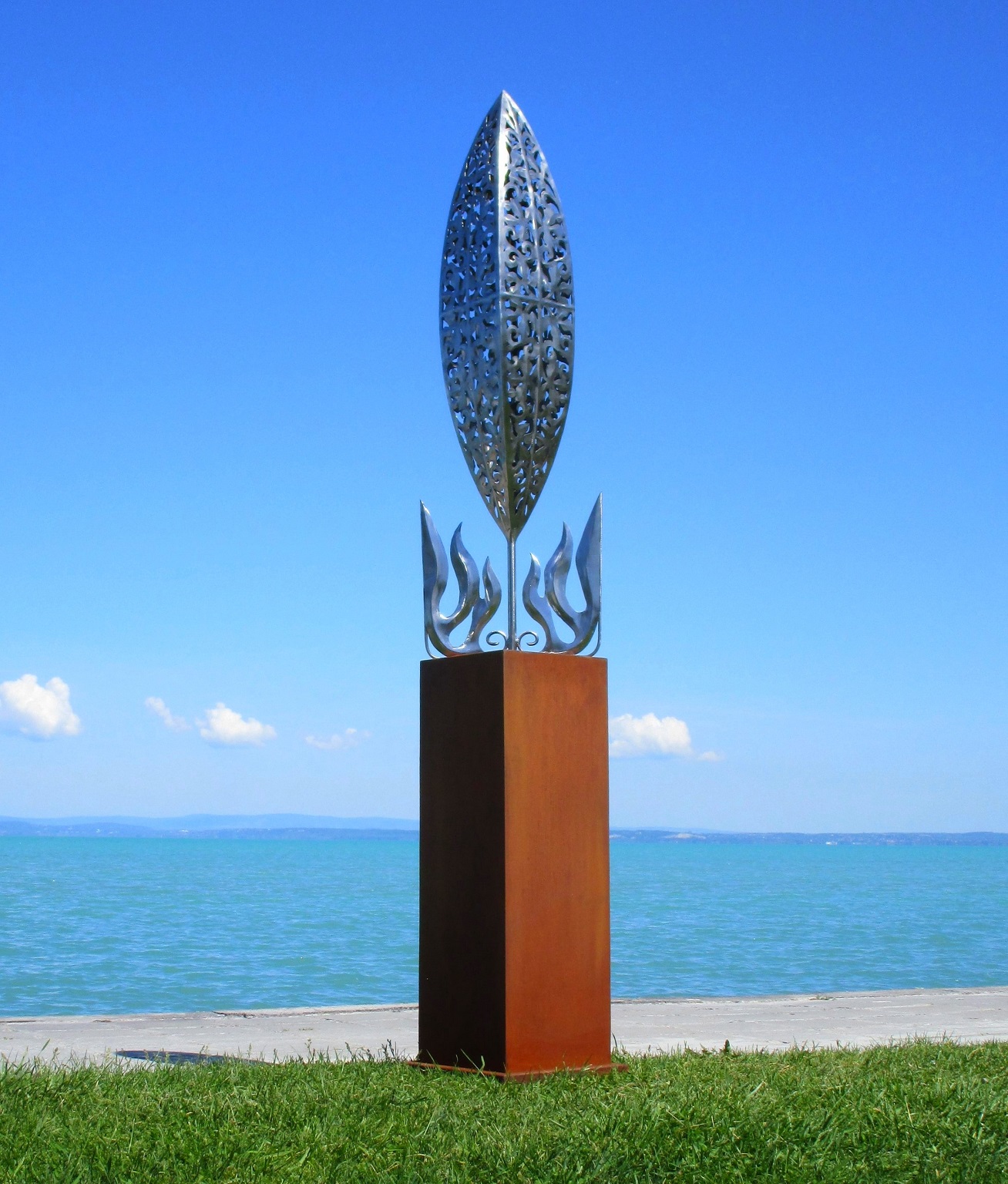 Big flame sculpture on rusty column - NEUERRAUM